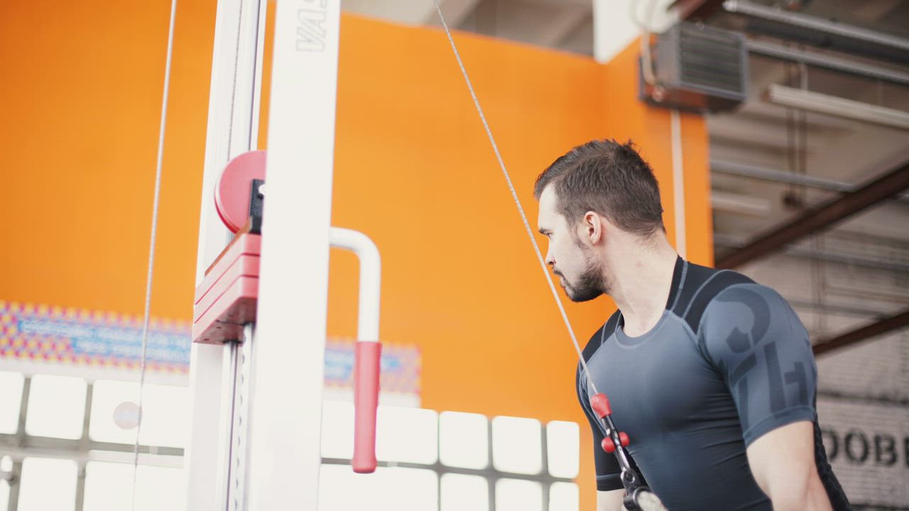 Man training with a pull down weight machine - Free Stock Video