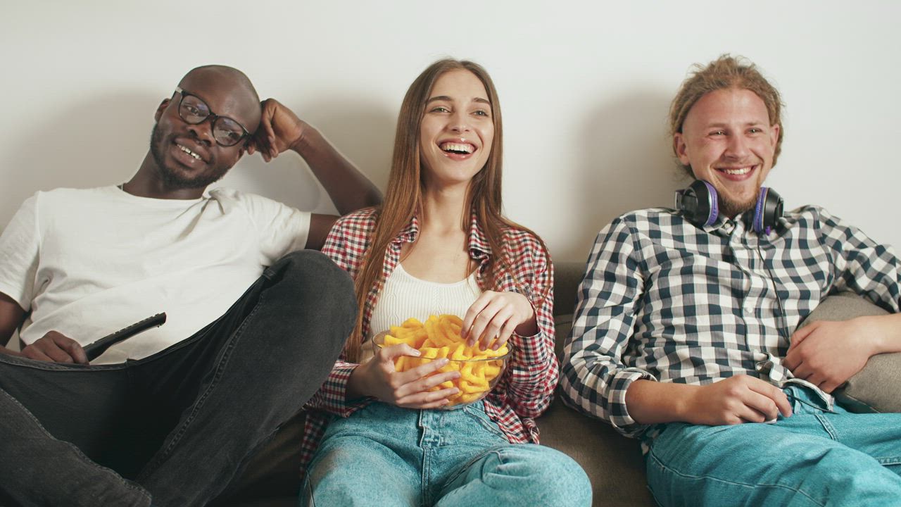 Friends watching a comedy show on TV - Free Stock Video