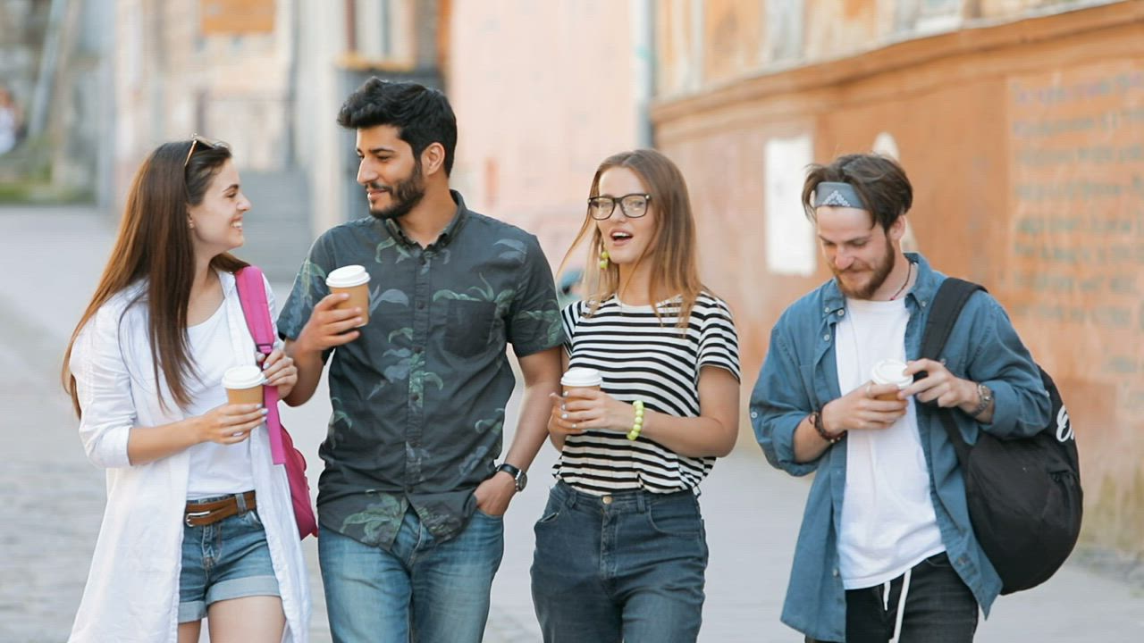 Happy friends walk down the street while talking - Free Stock Video