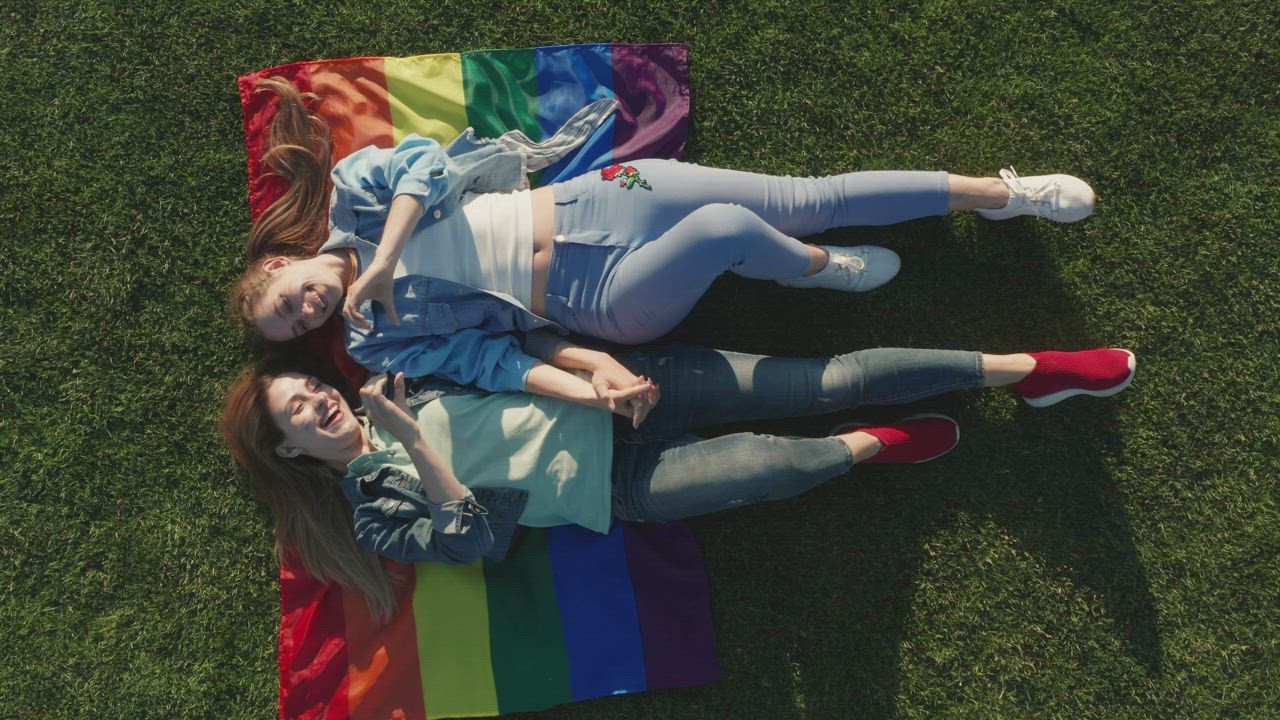Couple laying on a rainbow flag - Free Stock Video