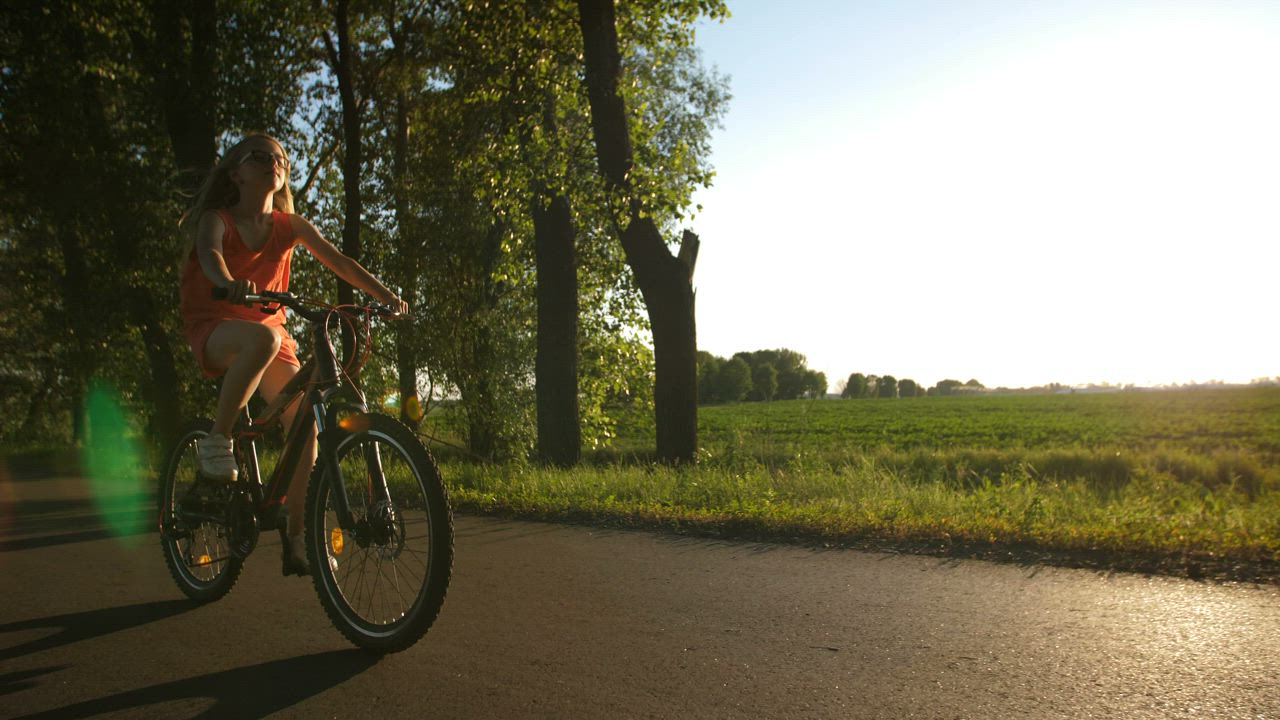 Girl riding a bike on a warm evening - Free Stock Video