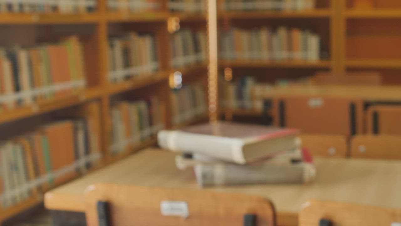 Focus on a stack of books in a library - Free Stock Video