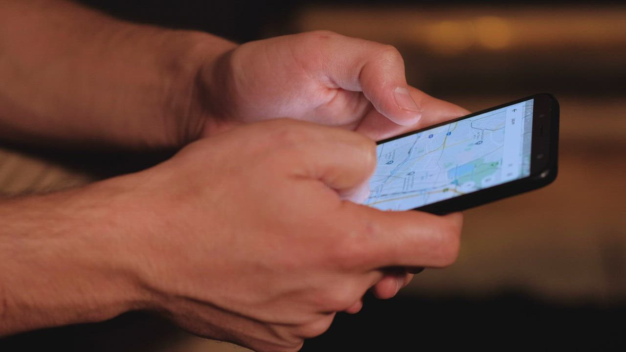 Hands of a person searching a map on his cell phone - Free Stock Video