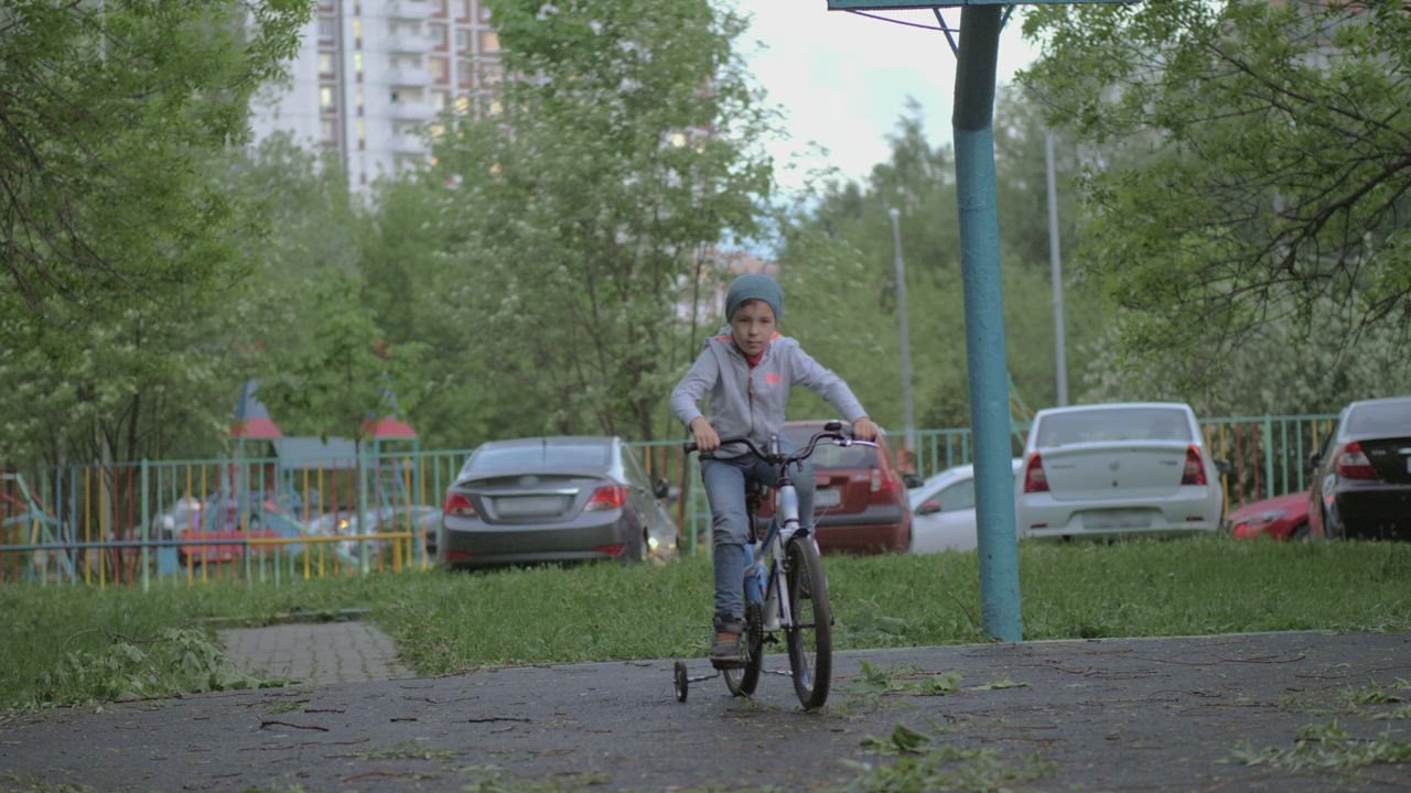 Child with training wheels on their bike - Free Stock Video