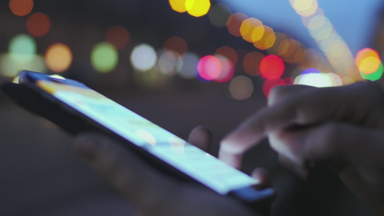 Texting in the city at night - Free Stock Video