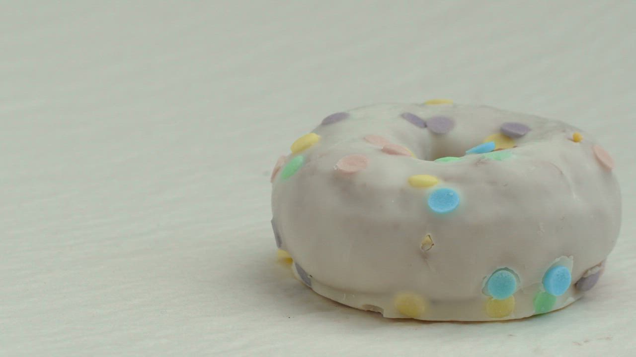 Adding candy to a donut - Free Stock Video