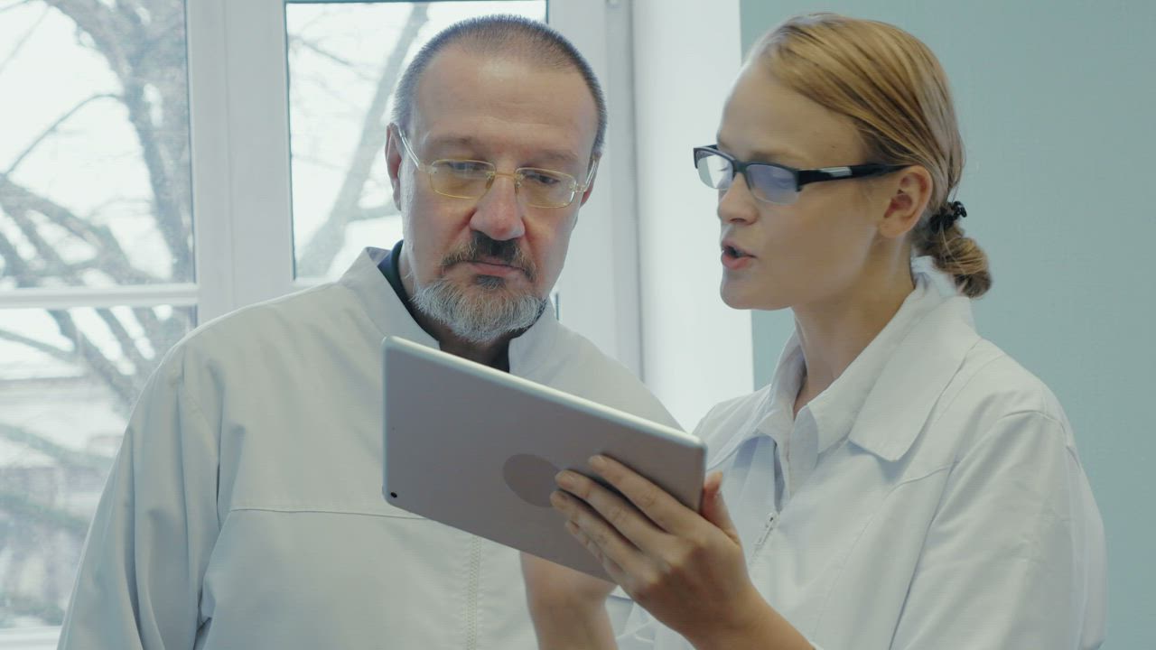 Doctor using a tablet to discuss treatments - Free Stock Video