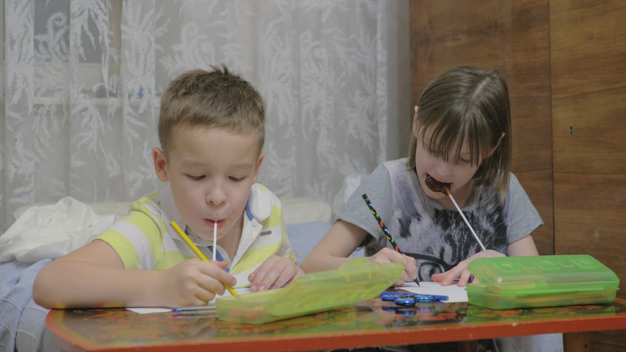 Children eating candy while drawing - Free Stock Video