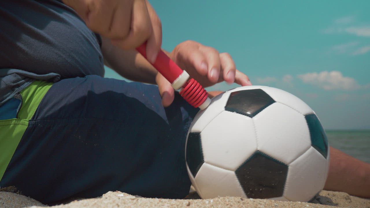 Inflating a ball at the beach - Free Stock Video