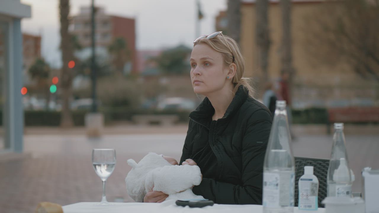 Sitting at a cafe table with her baby - Free Stock Video