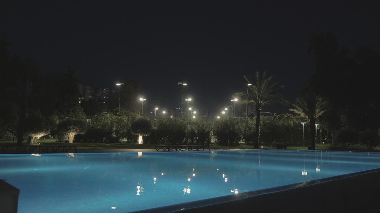 Illuminated hotel pool at night - Free Stock Video