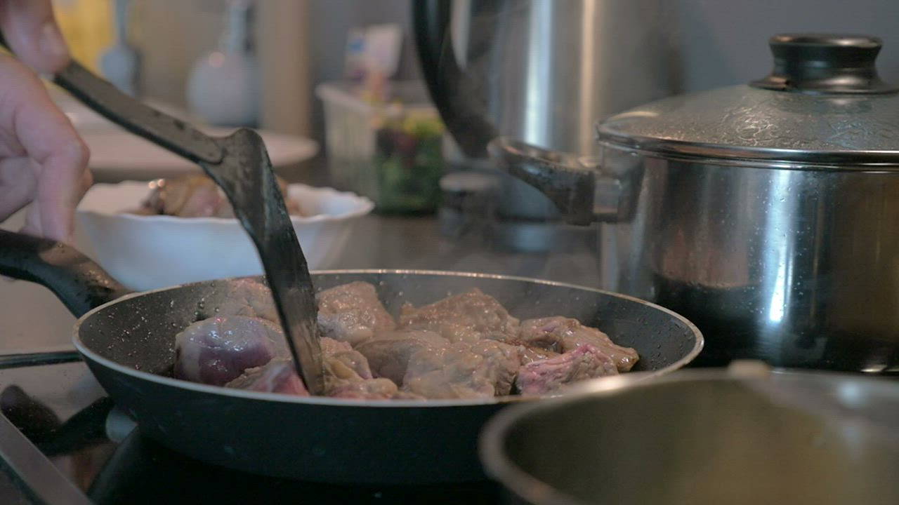 Turning meat in a frying pan - Free Stock Video
