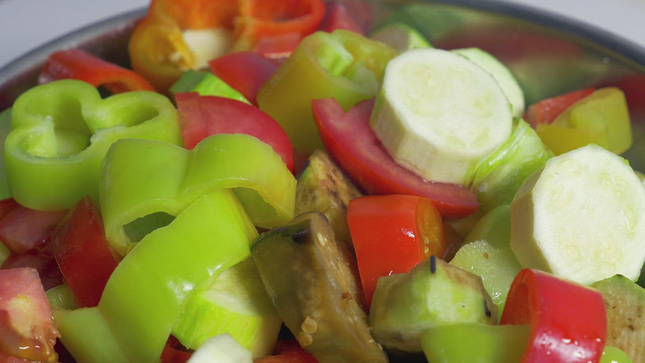 Adding sliced vegetables to a dish - Free Stock Video