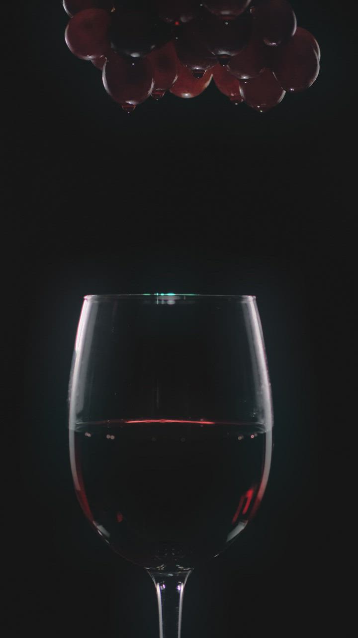 Bunch of grapes dripping wine into a glass - Free Stock Video
