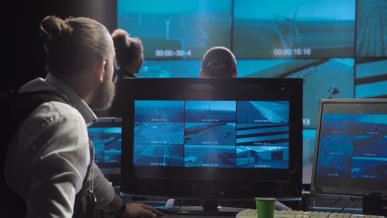 Surveillance team looking at monitors - Free Stock Video