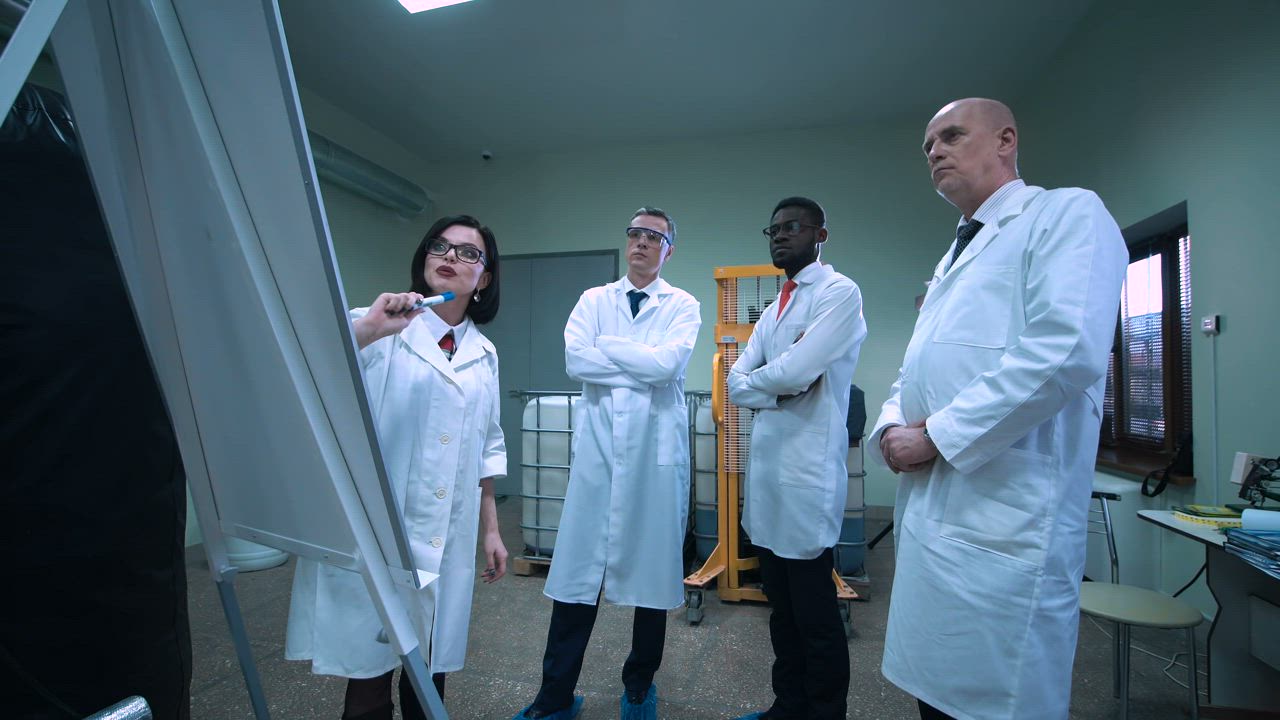 Female scientist explaining an idea on the board - Free Stock Video