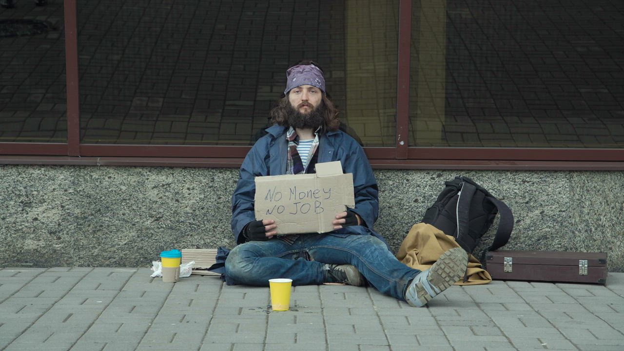 A homeless man begging sitting on the street - Free Stock Video