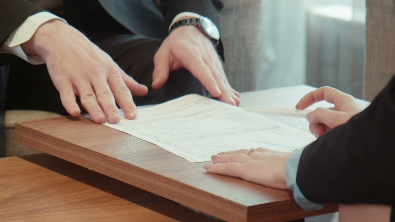 Signing on a contract on a wooden table - Free Stock Video