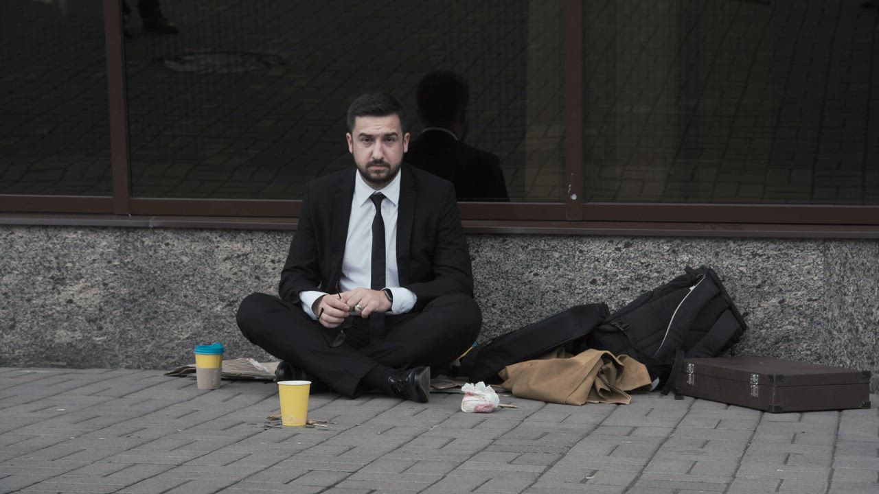 Man taking off his tie sitting on the street - Free Stock Video