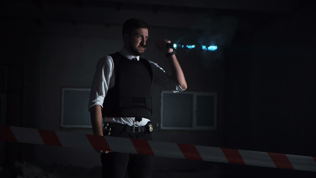 Police officer with a flashlight smoking - Free Stock Video