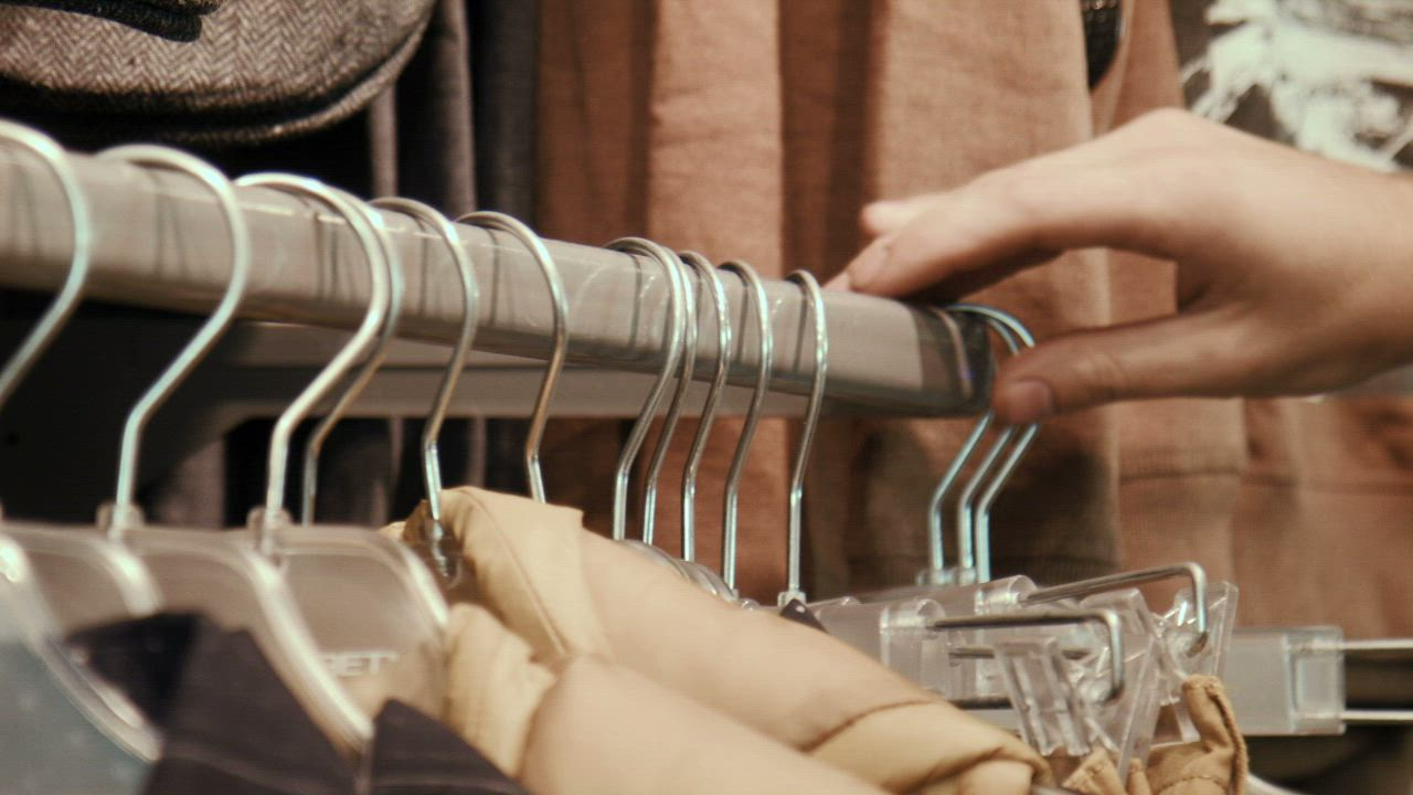 Hand selecting through clothes - Free Stock Video