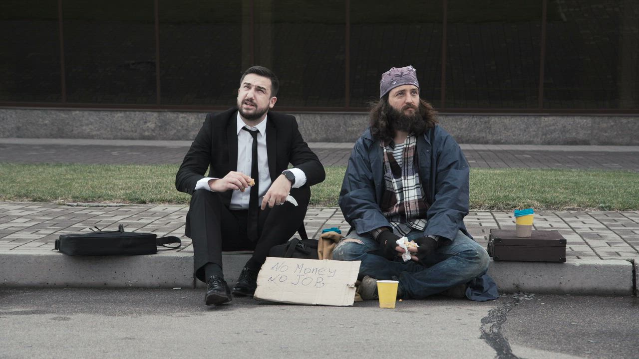 Businessman and homeless sitting on the sidewalk - Free Stock Video