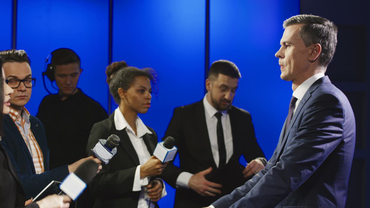 Man in a suit gives an interview to reporters - Free Stock Video