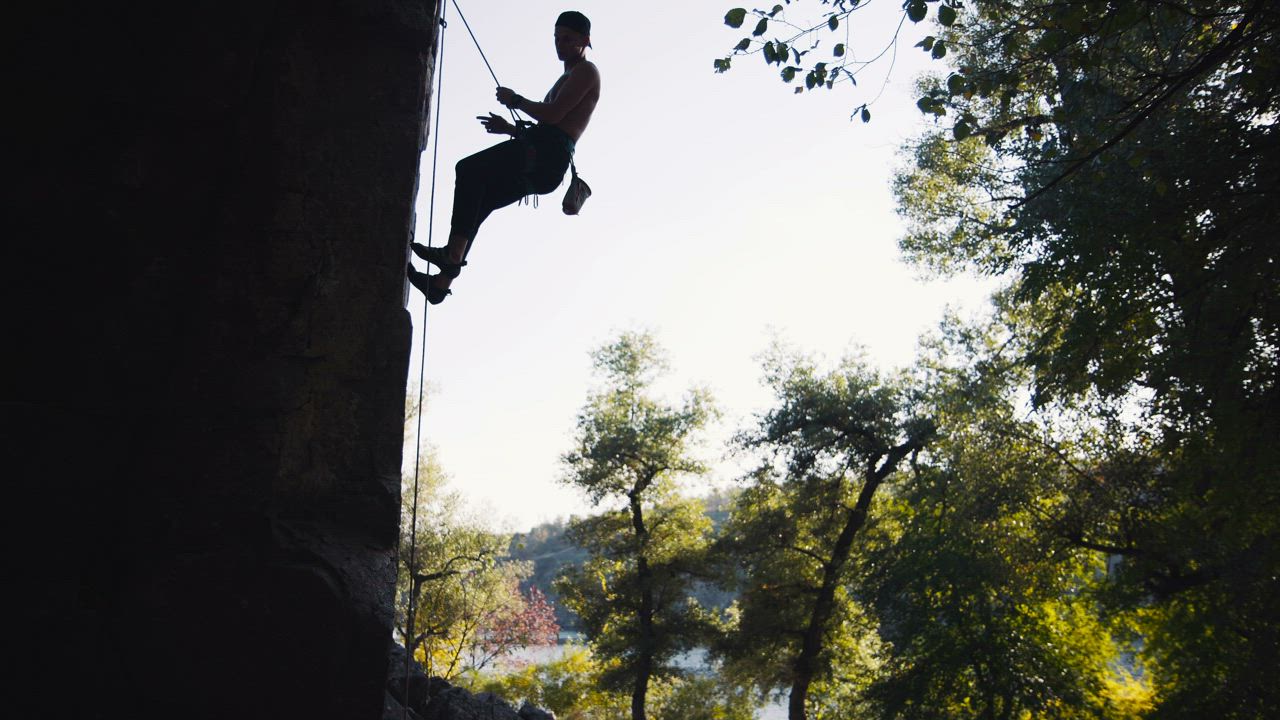 Silhouette of a man doing an abseil - Free Stock Video