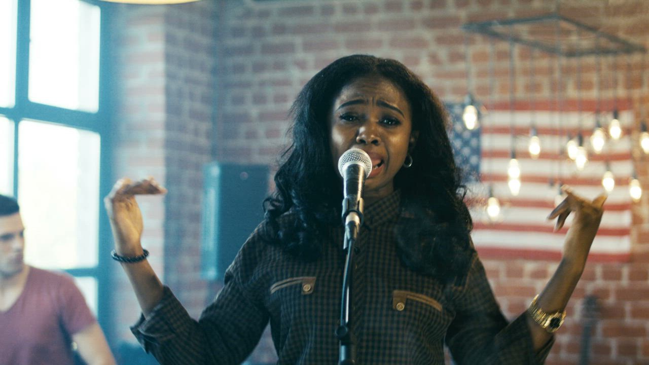 A singer performing with a band indoors - Free Stock Video