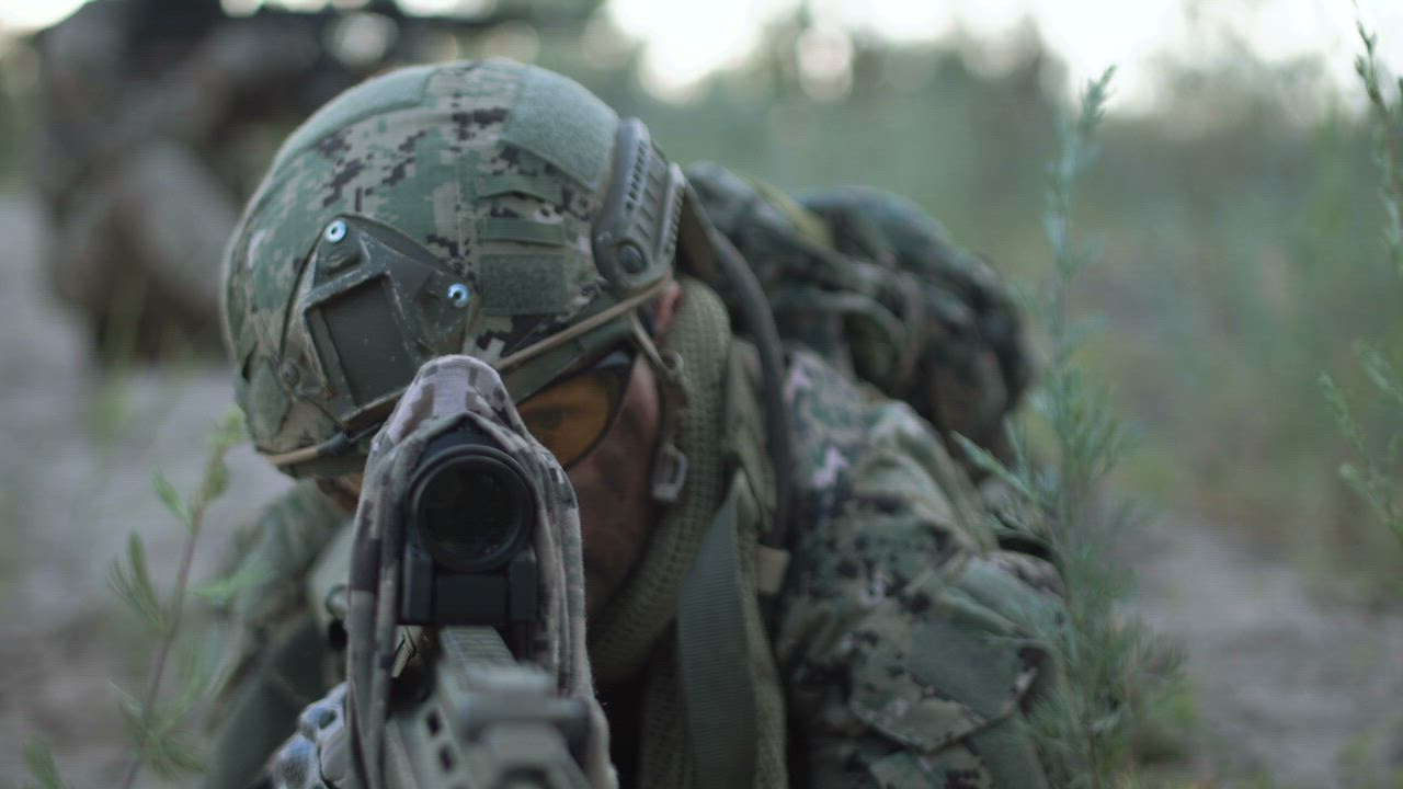 A sniper laying on the ground is aiming - Free Stock Video