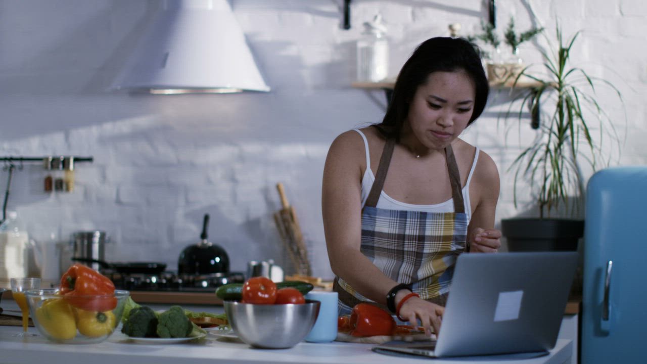 Preparing food following a tutorial in the kitchen - Free Stock Video