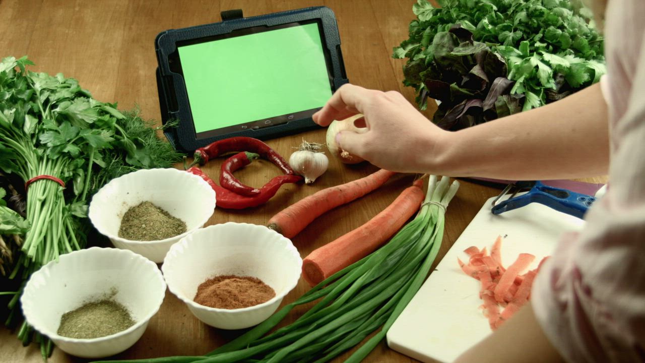 Cooking and using tablet - Free Stock Video