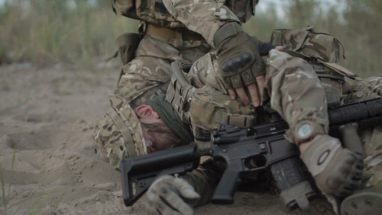 Helping a wounded soldier in the battlefield - Free Stock Video
