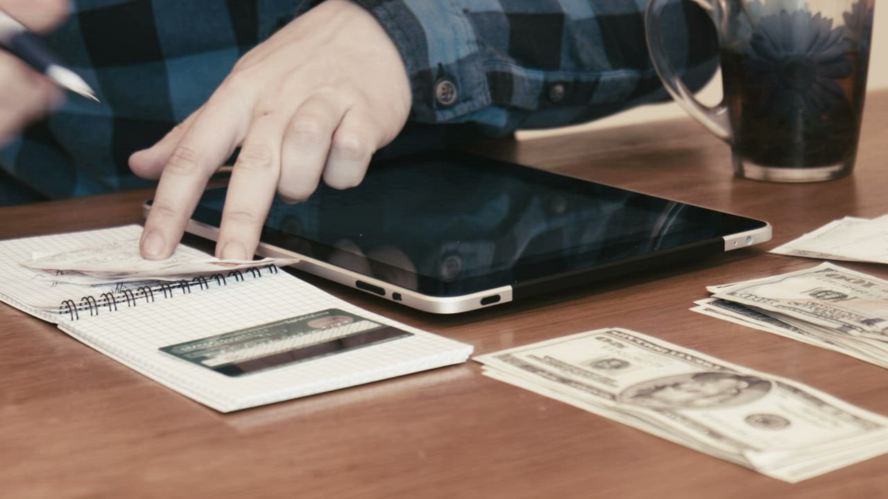 A man separating money into budgets - Free Stock Video