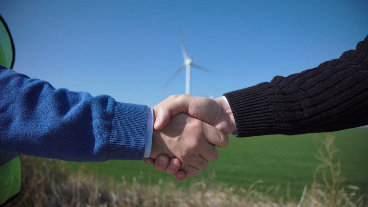 Handshake against wind turbines - Free Stock Video