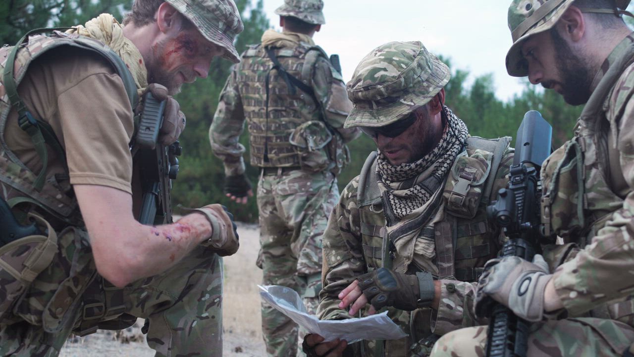 Soldiers discussing where to go on the map - Free Stock Video