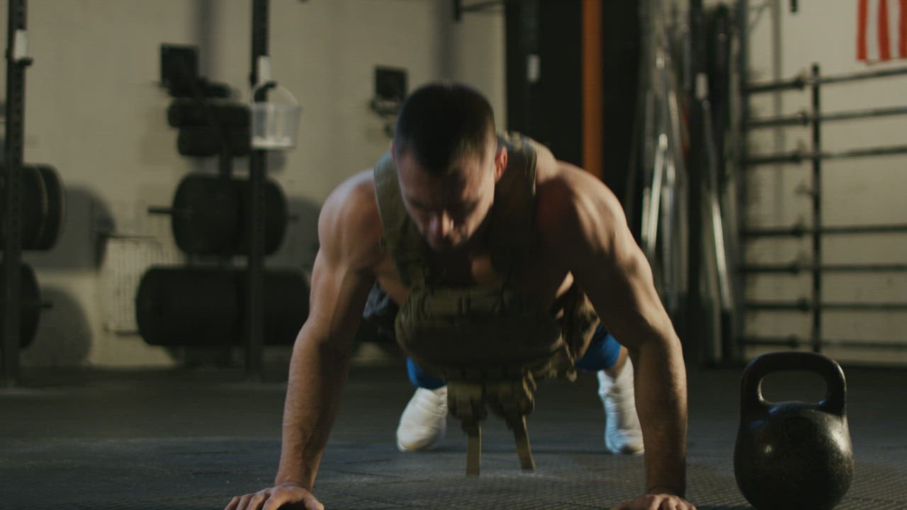 Muscular man doing push-ups in the gym - Free Stock Video