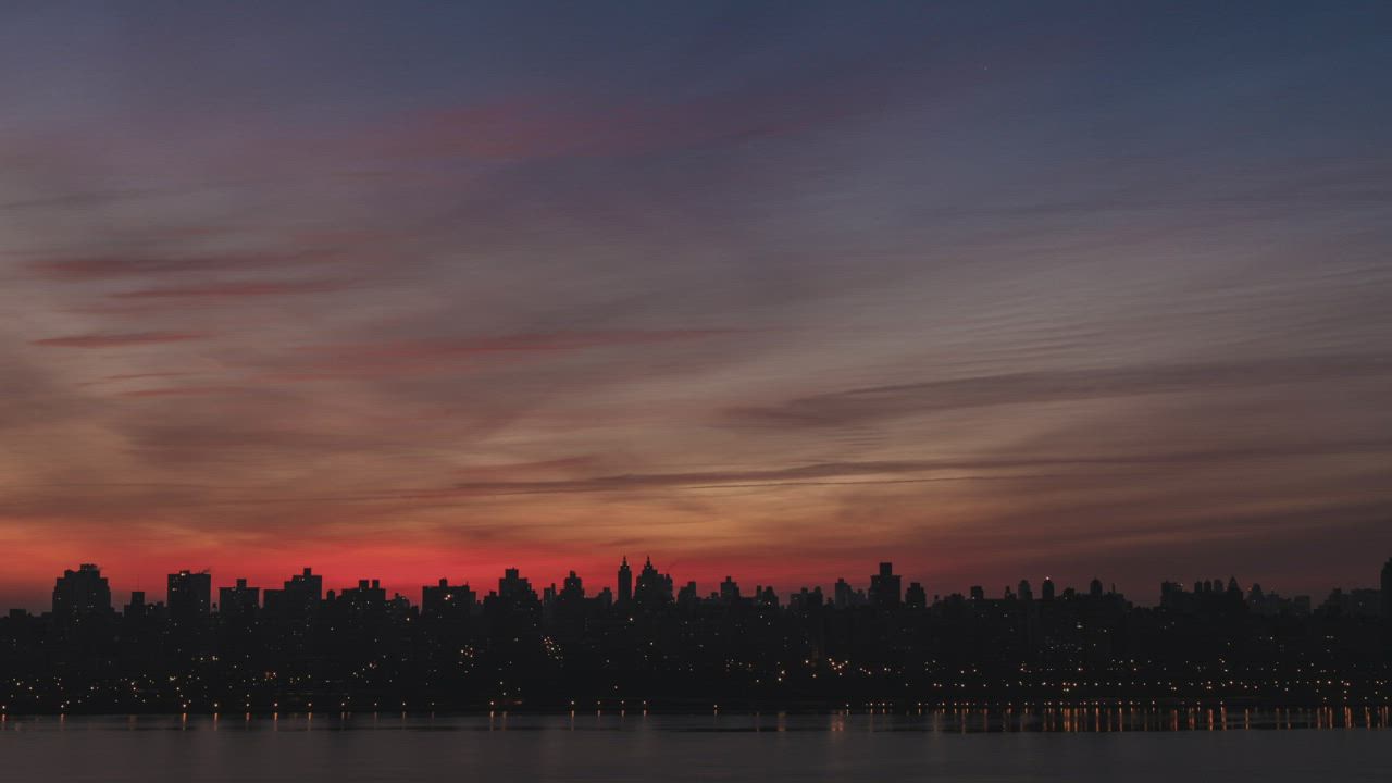 Deep red sky behind a city - Free Stock Video