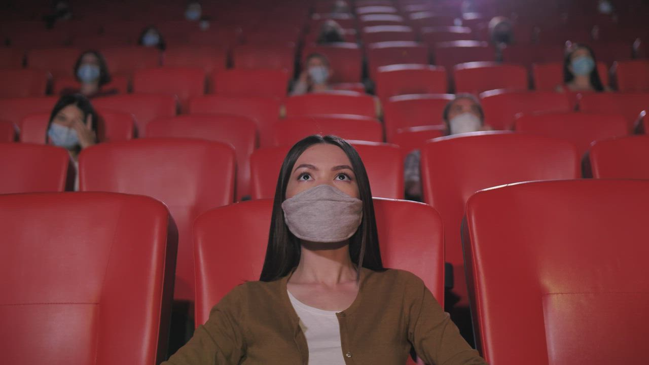 Woman wearing a mask at the cinema - Free Stock Video