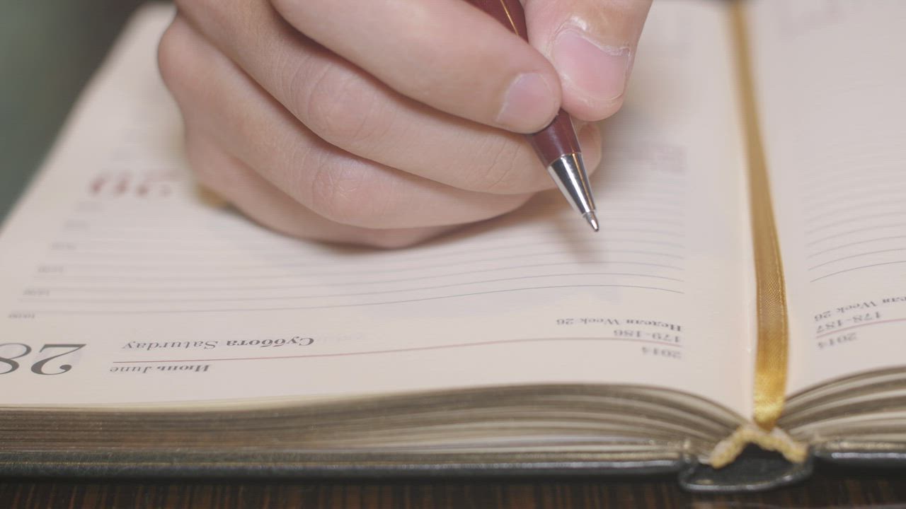 Writing in a paper notebook - Free Stock Video