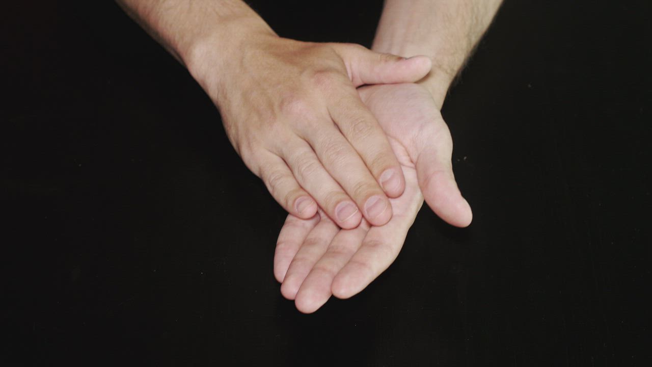 Hands clapping against a dark background - Free Stock Video