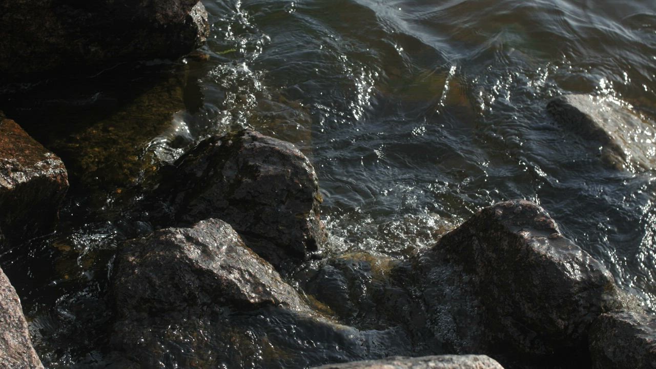 Waves breaking over harbor rocks - Free Stock Video