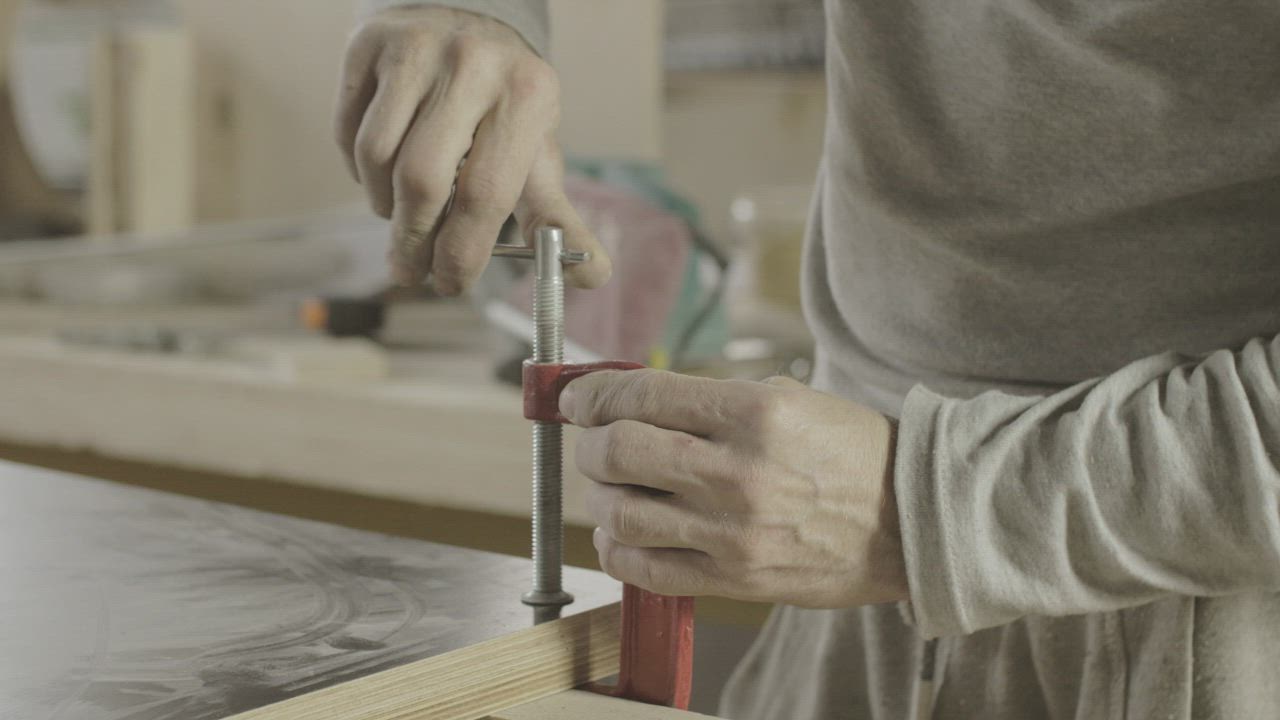 Carpenter clamping wood down - Free Stock Video