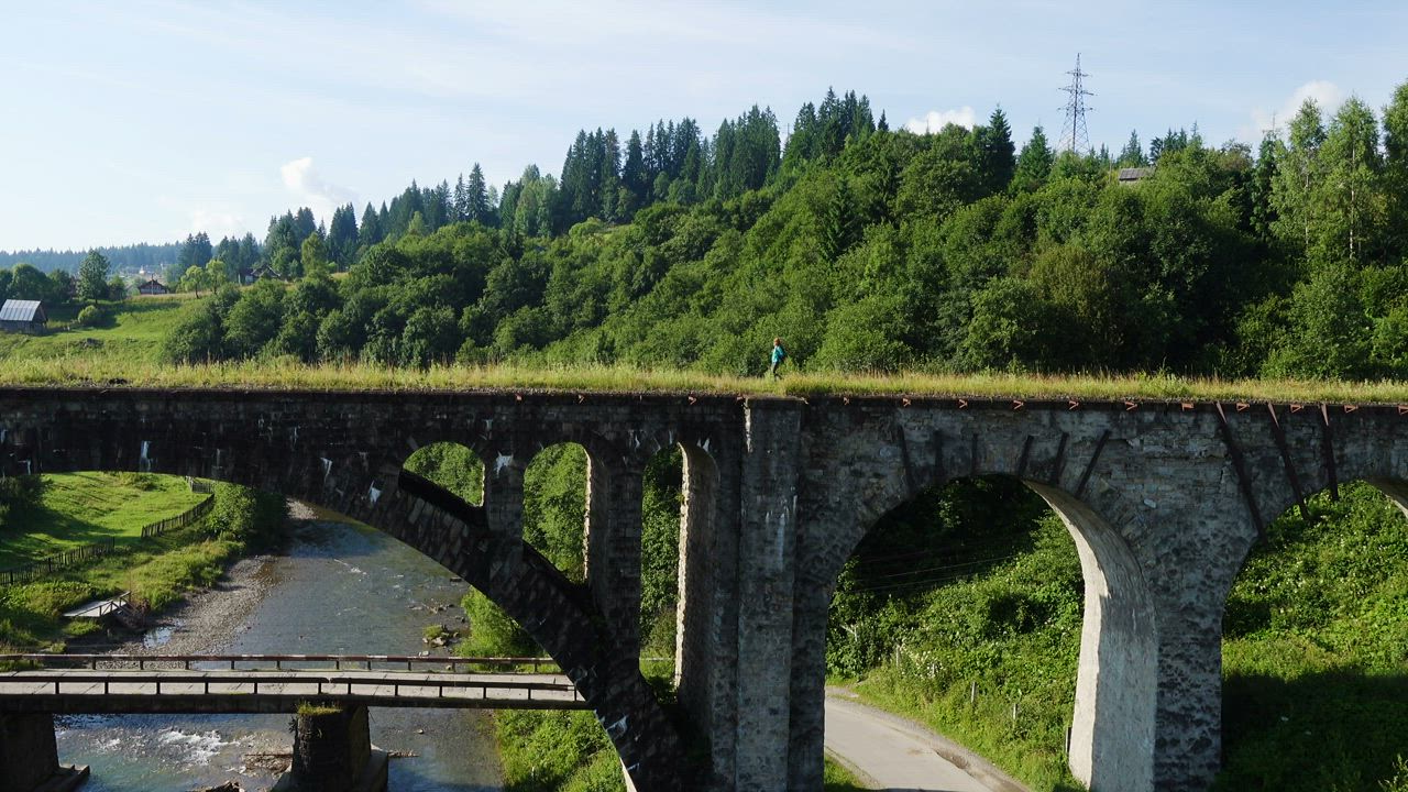 Walking above an ancient stone bridge - Free Stock Video