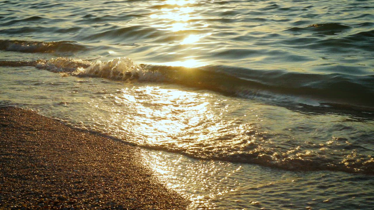 Sun reflections and gentle waves in the beach - Free Stock Video