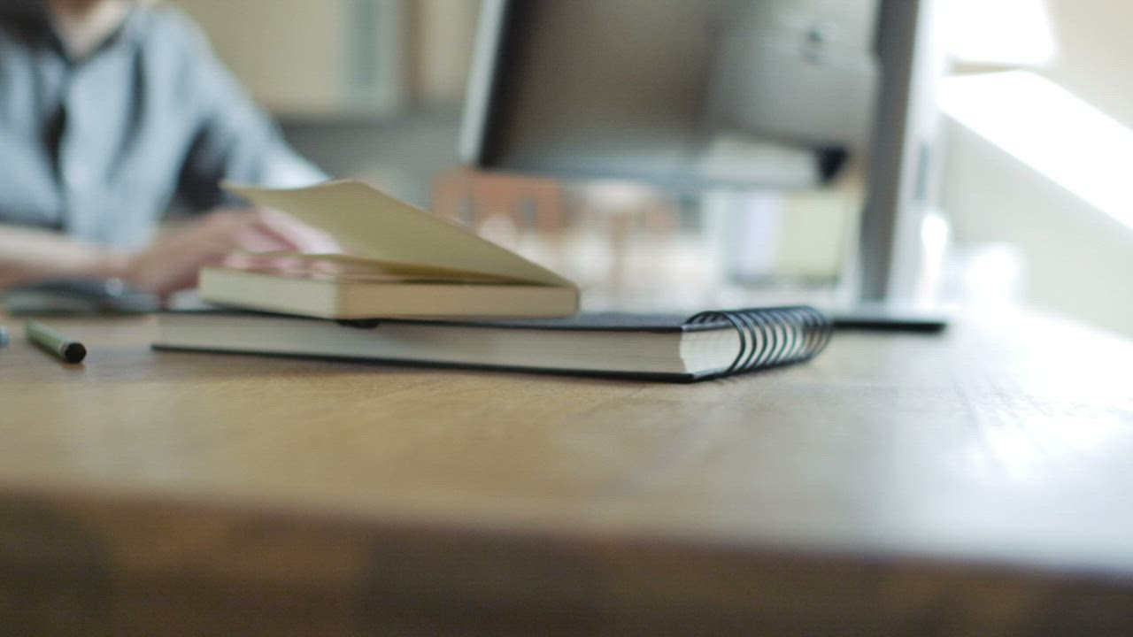 Office objects and a man working in the background - Free Stock Video