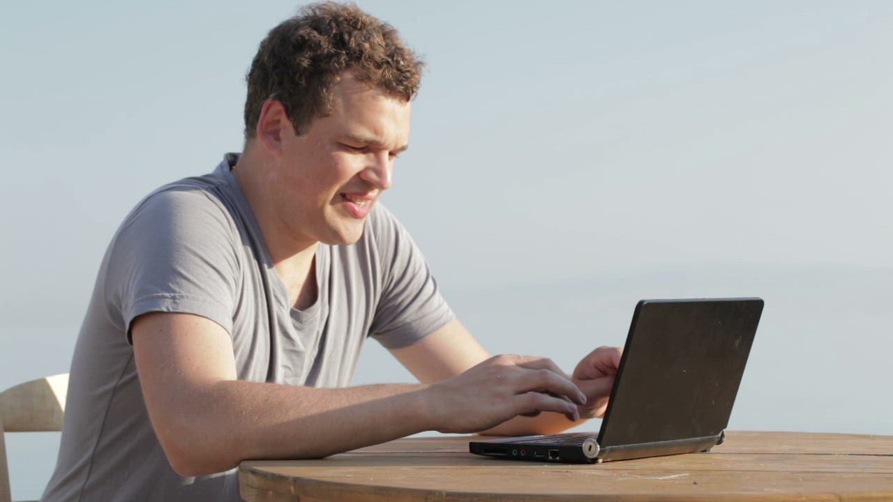 Man typing on a small personal computer - Free Stock Video