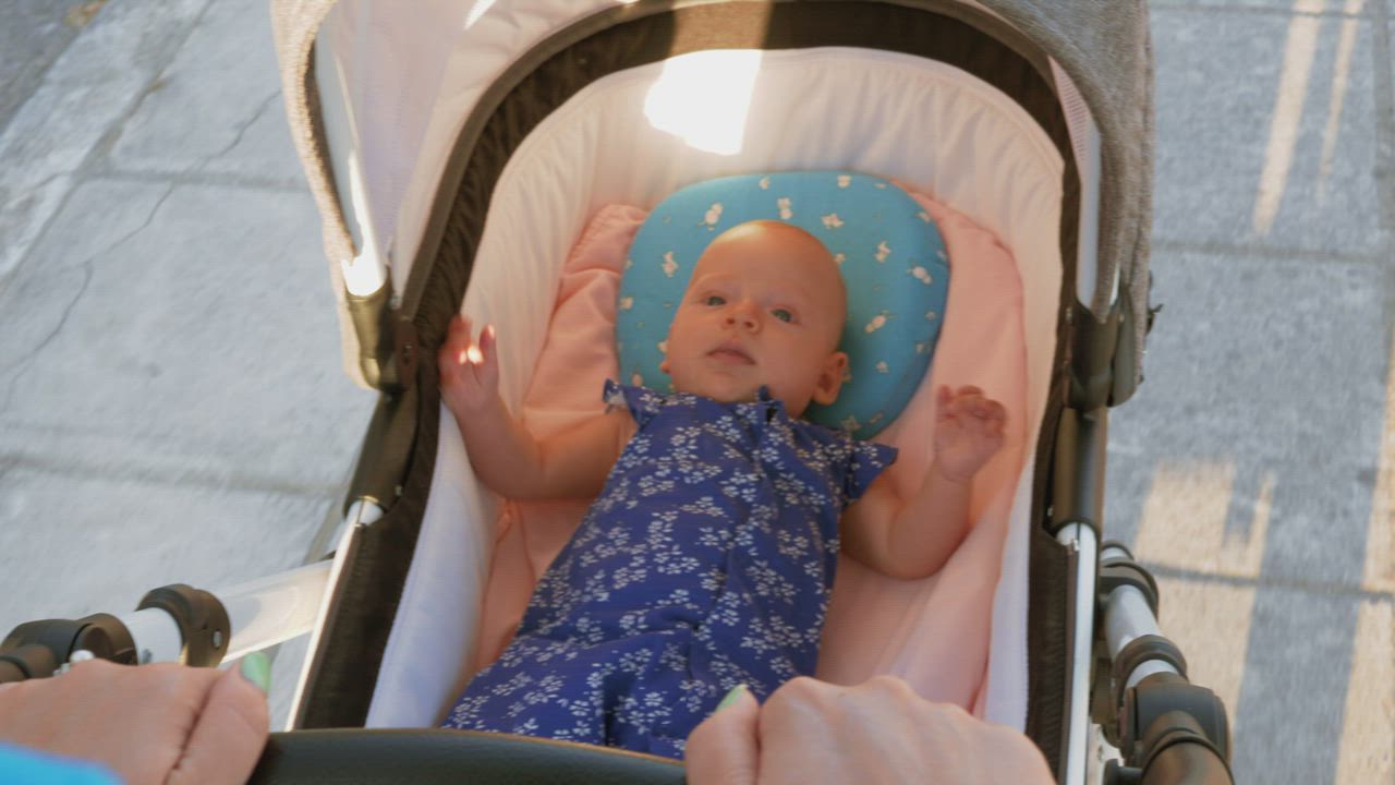 Pushing a young baby in a pram - Free Stock Video