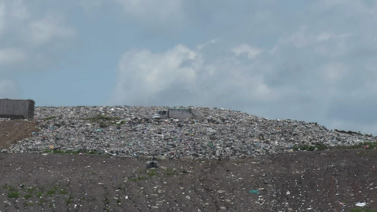 A couple of trucks crossing a hill in a dump - Free Stock Video