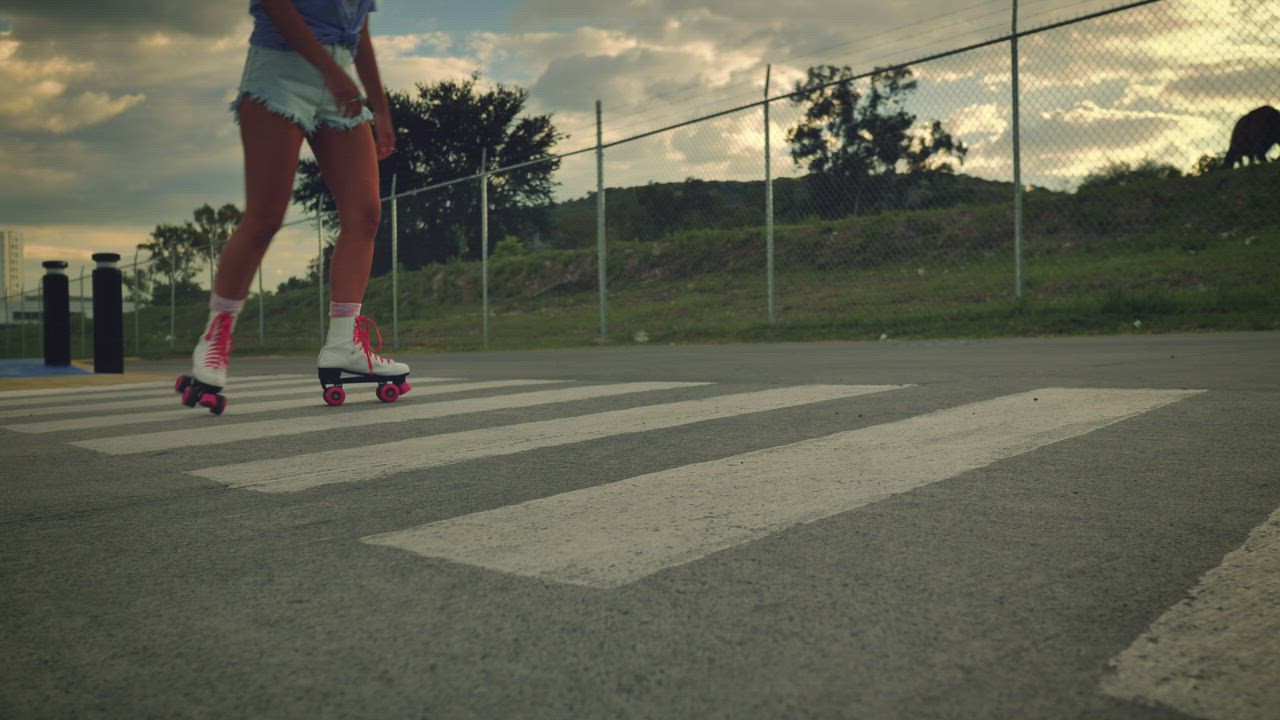 Girl crossing an empty street skating on roller skates - Free Stock Video